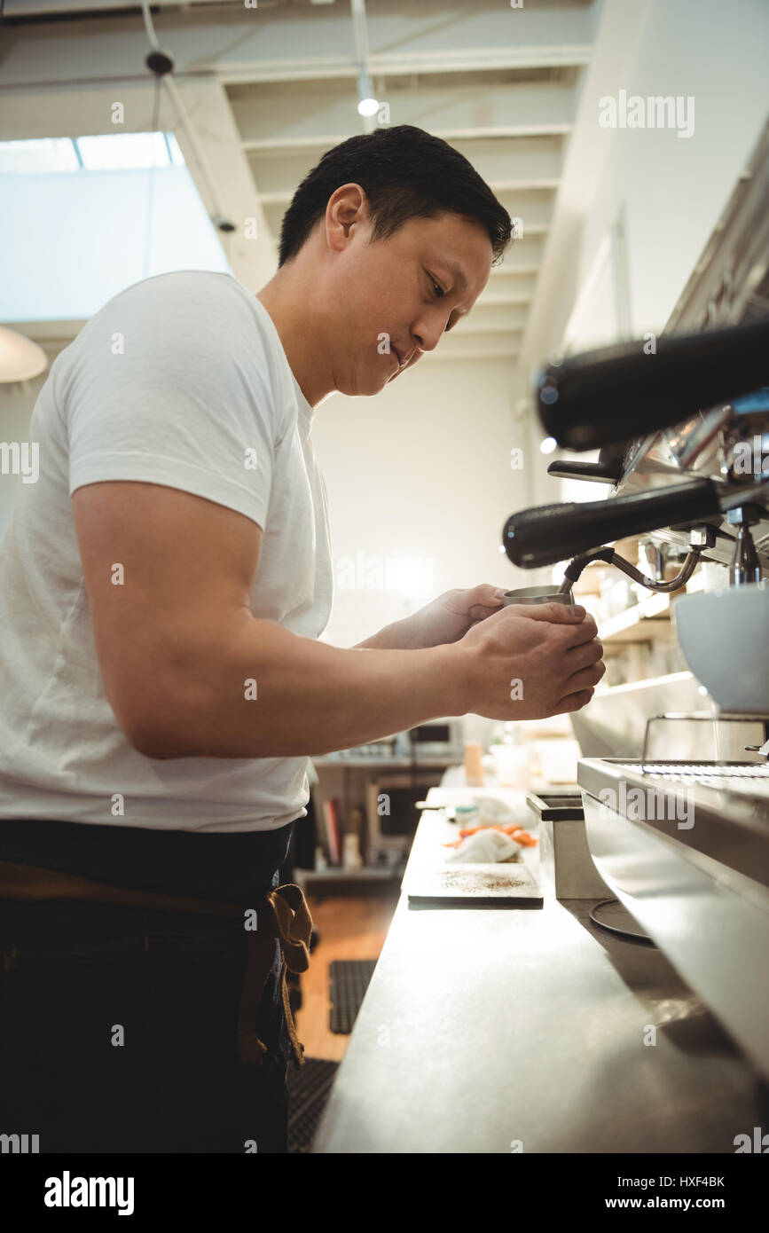 Side view of male barista using espresso machine in coffee shop Stock ...