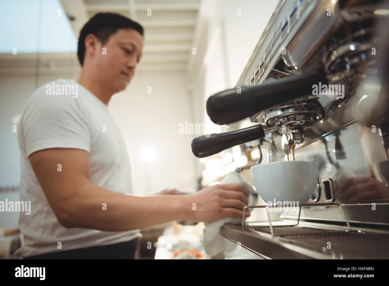 Side view of male barista making espresso in coffee shop Stock Photo ...