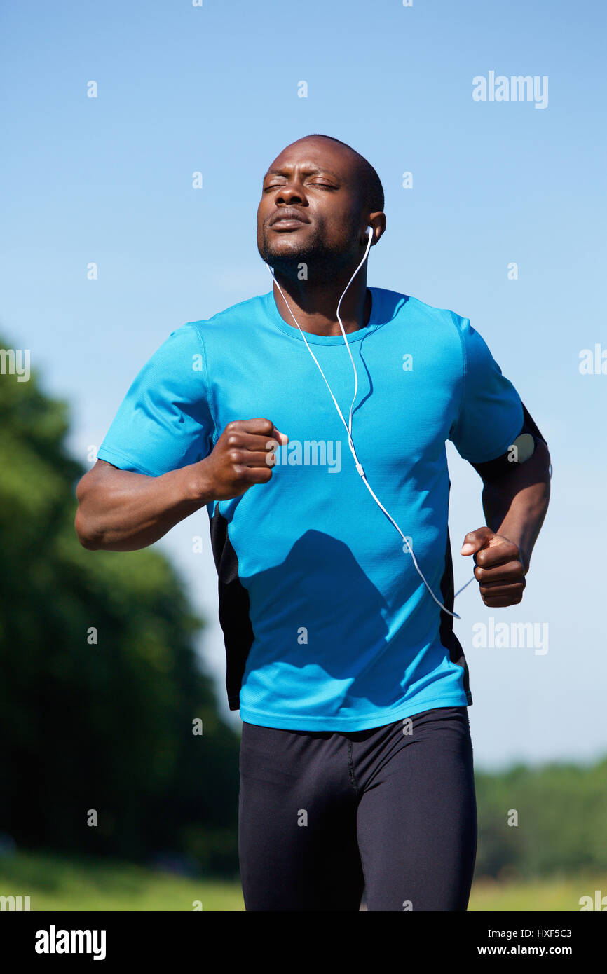 Portrait of a fit young black man running outdoors Stock Photo - Alamy