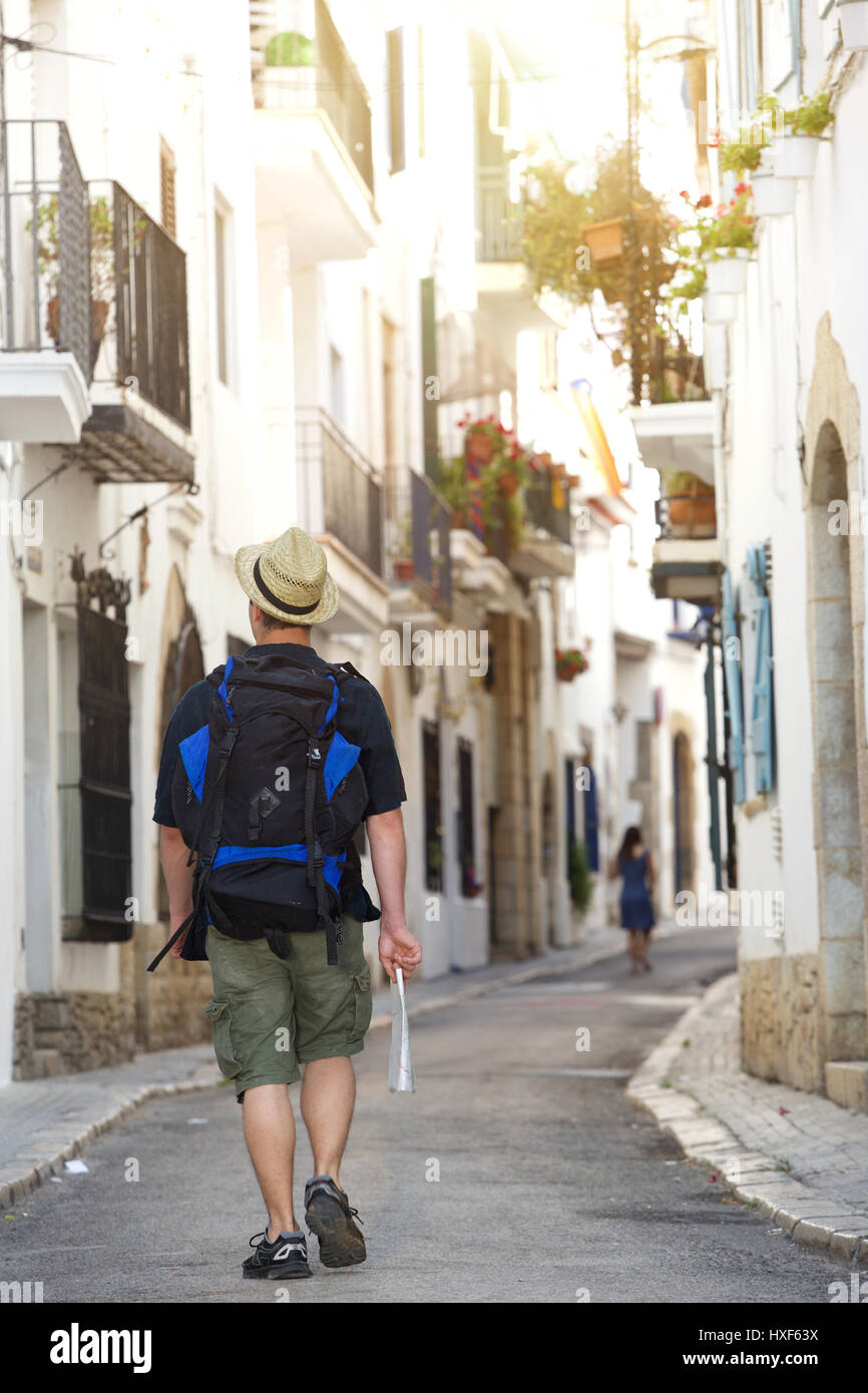Traveling man walking with bag and map - from behind Stock Photo - Alamy