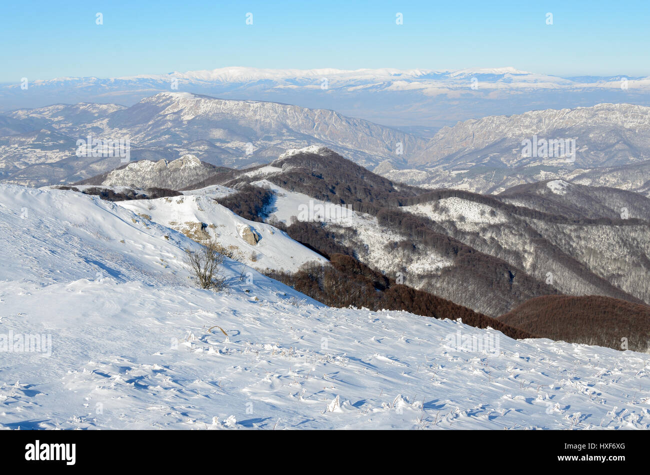 Wintry landscape with snow covered hills and layers of mountains Stock ...