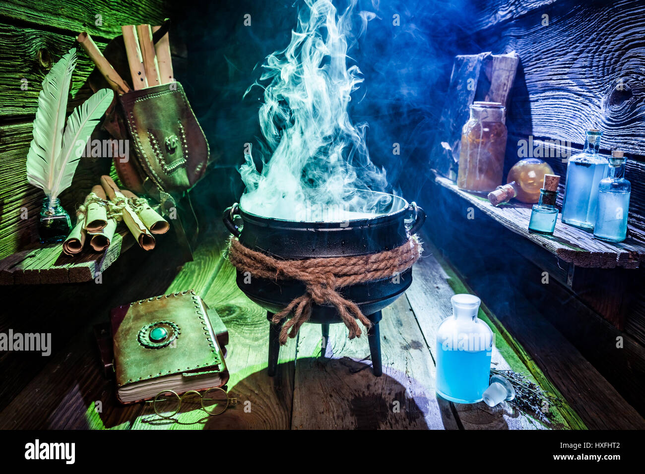 Vintage witch pot with magic mixture, blue potions and books for ...