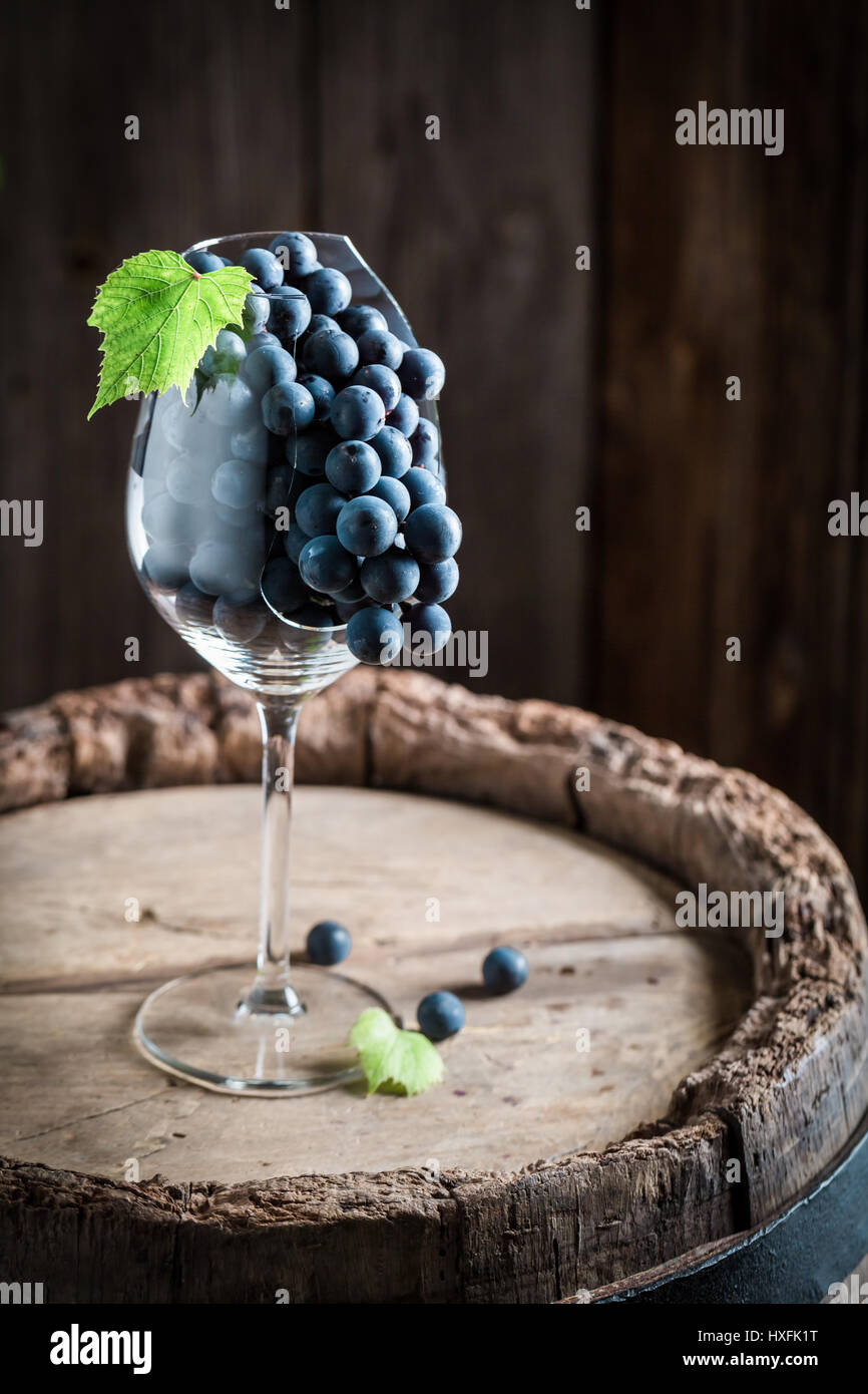 Ripe red grapes in broken glass on wooden barrel Stock Photo - Alamy
