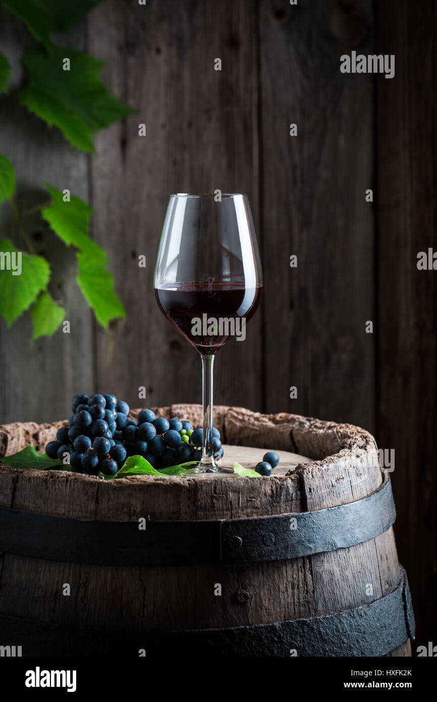 Fresh red wine on barrel with grapes Stock Photo - Alamy