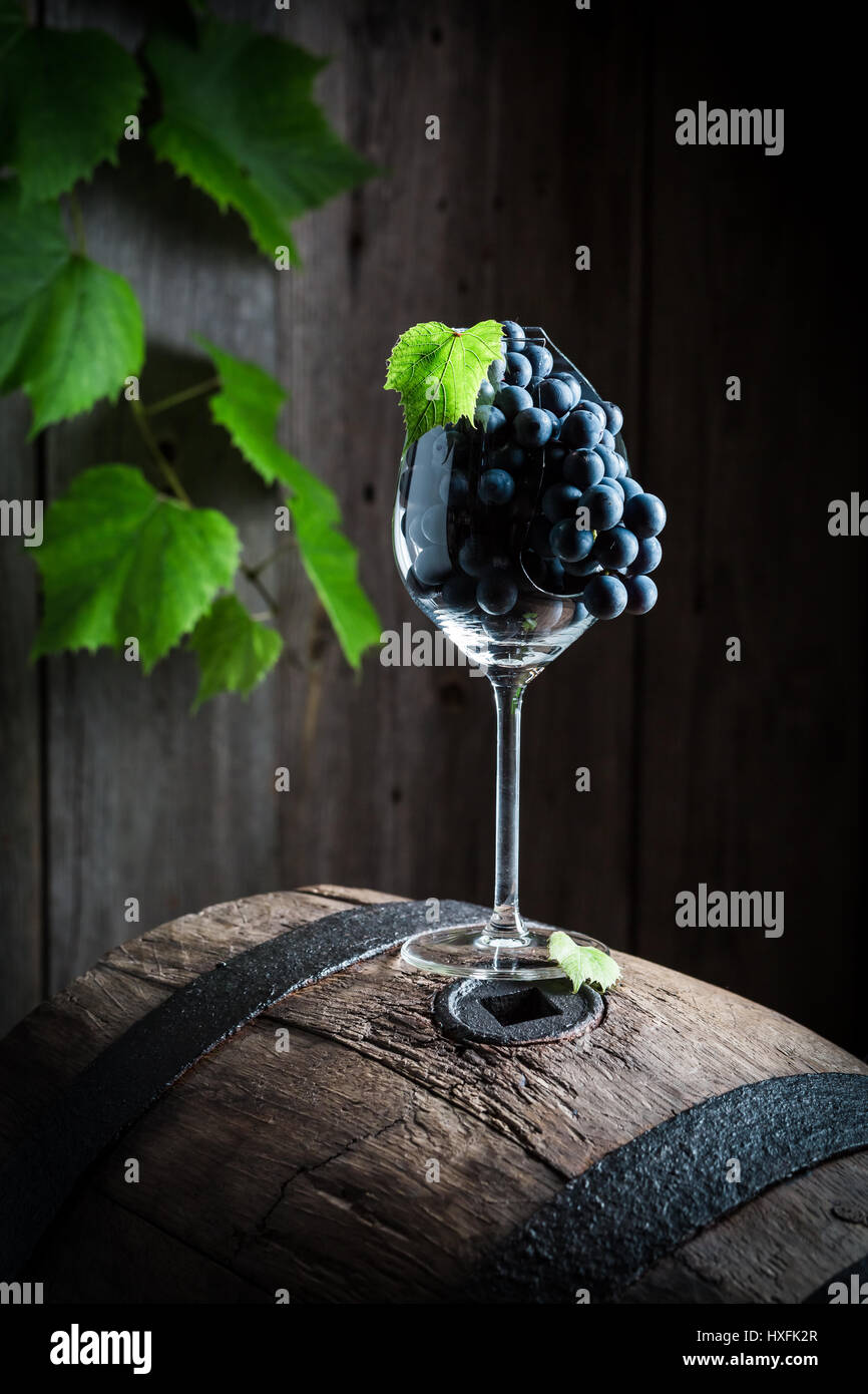 Red grapes in glass on old barrel of wine Stock Photo - Alamy