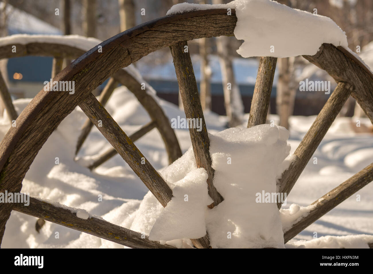 Antique Wagon wheel mostly buried in snow at Chena Hot Springs resort ...