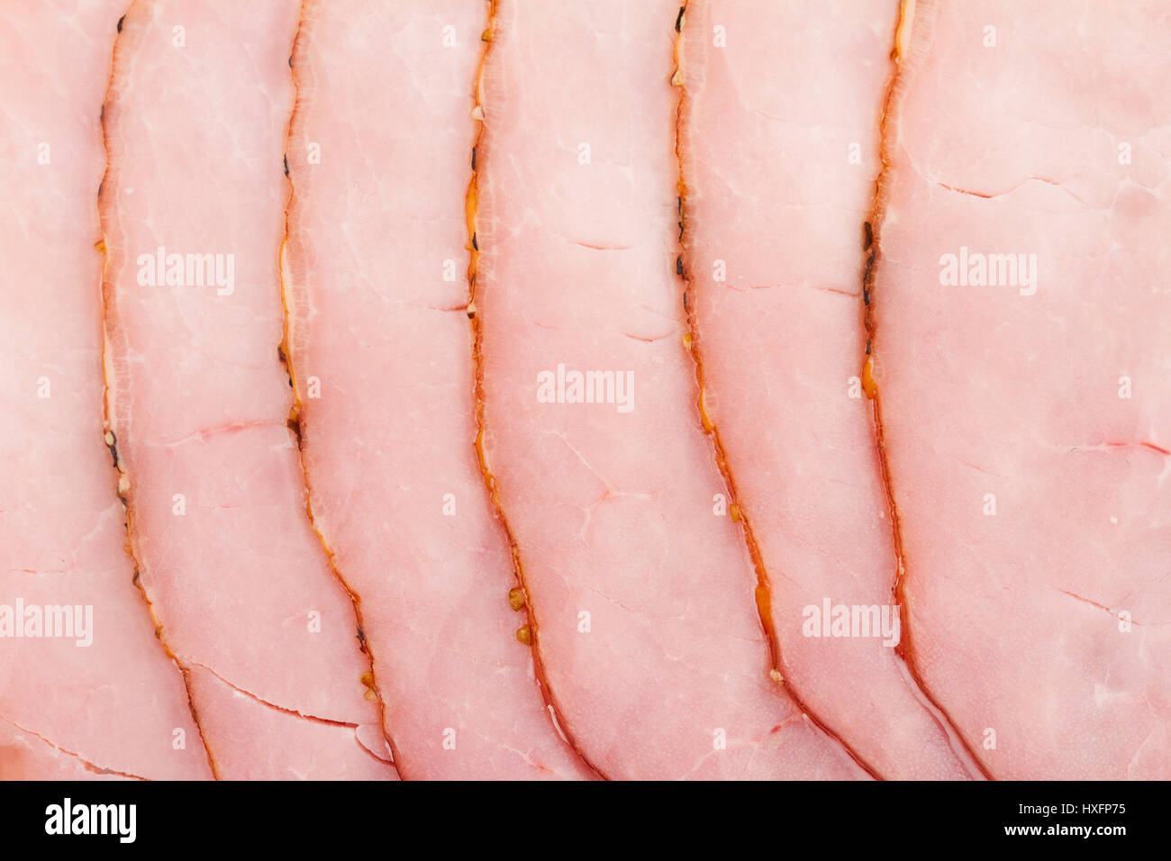 top view closeup of slices of smoked pork loin ham arranged in a stack ...