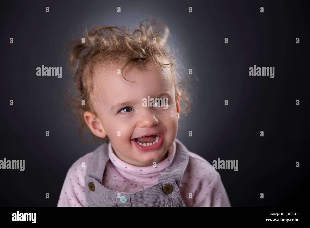 Portrait of a two years girl laughing. Studio shot. Black background ...