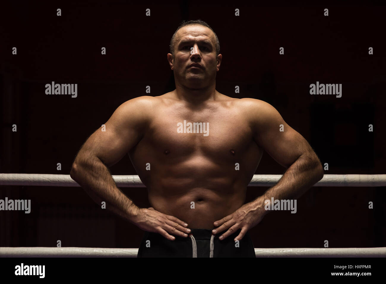portrait of muscular professional kickboxer who standing in the ring ...