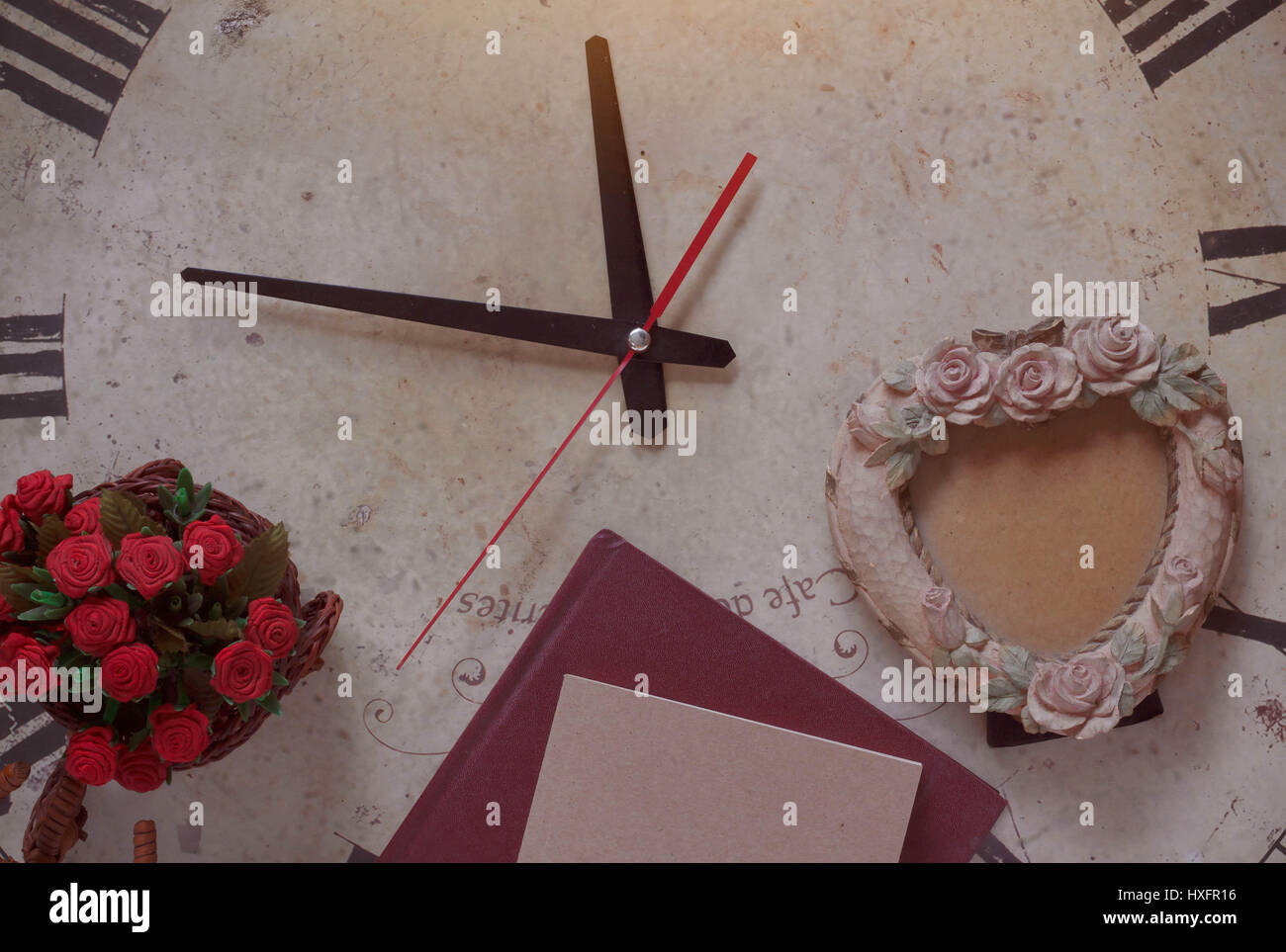 Book and photo frame on old antique clock Stock Photo - Alamy
