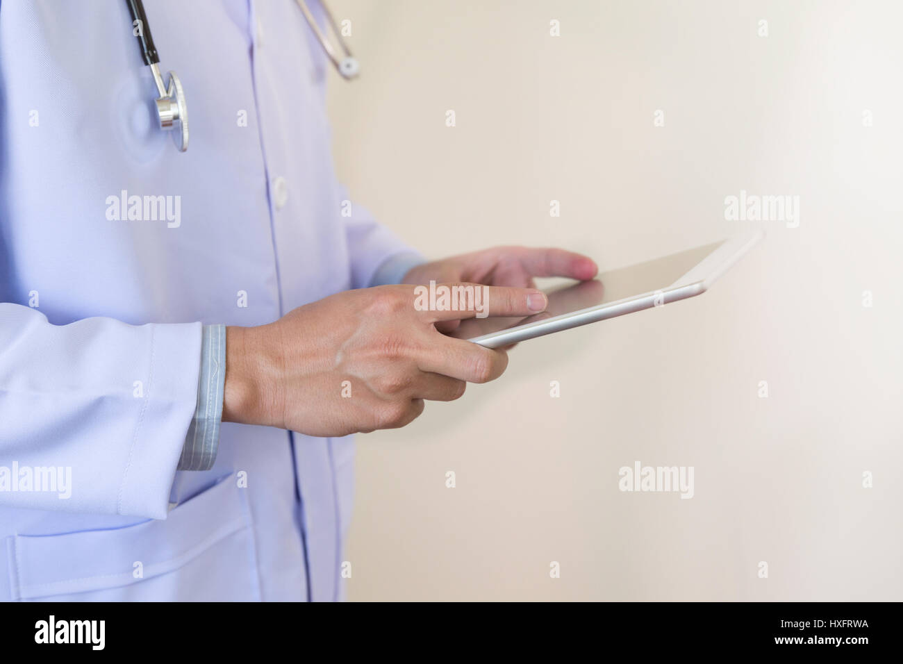 medical doctor in white lab coat using his tablet computer at work ...