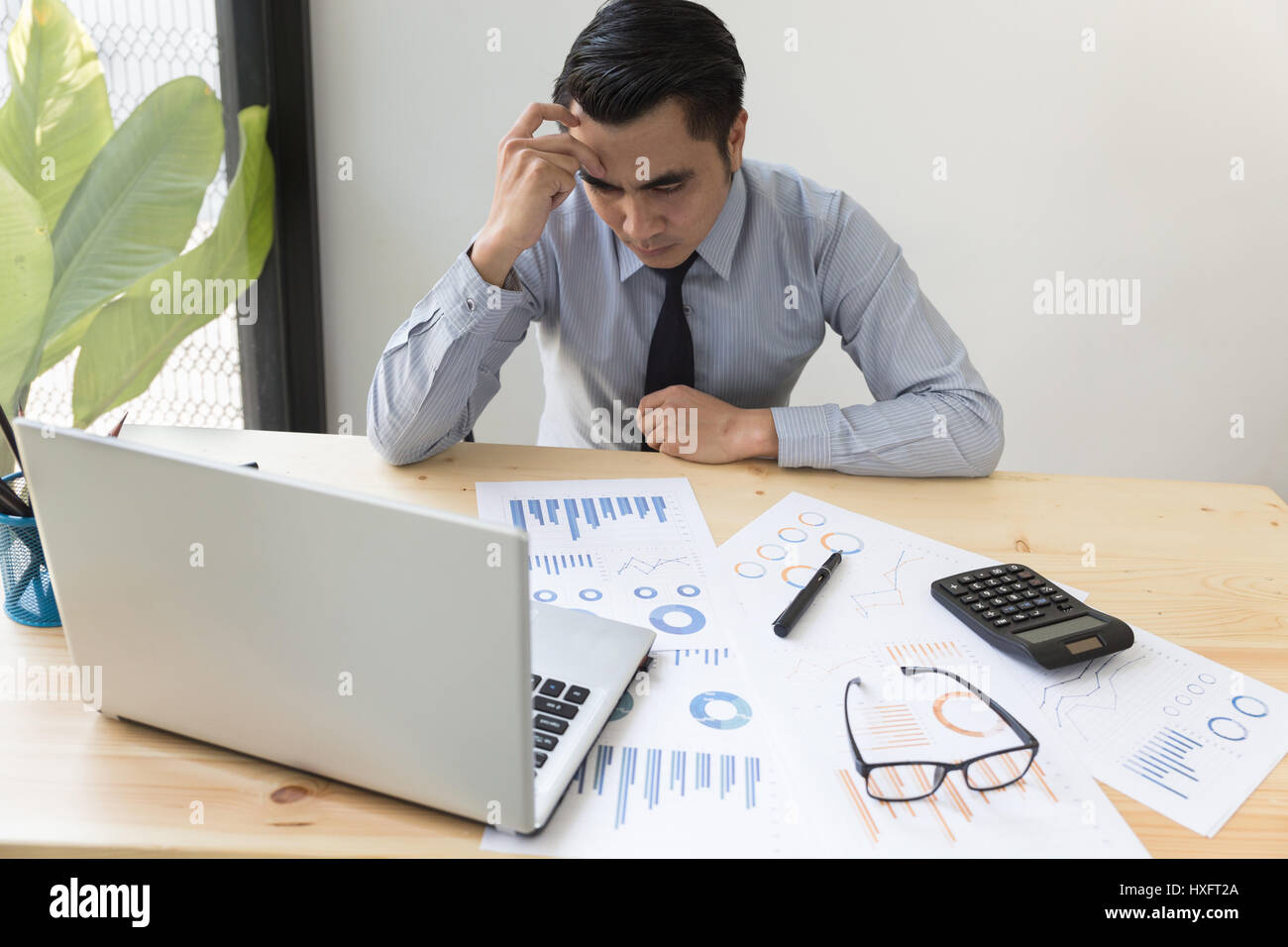 Young stressed and overworked businessman in modern office Stock Photo ...