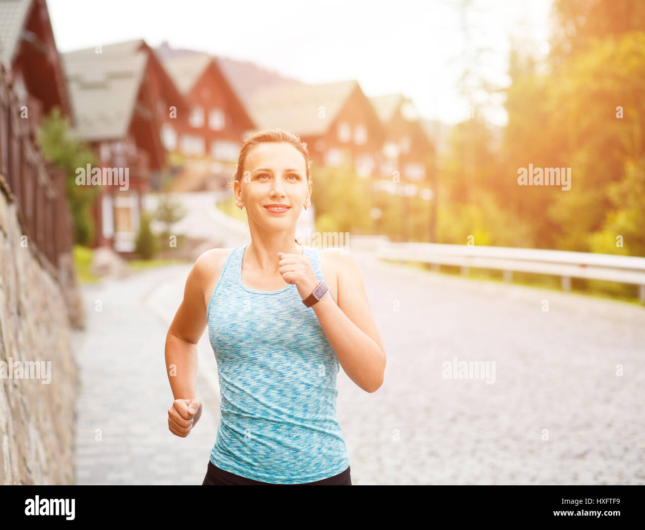 Young athletic girl running on the road in the morning. Attractive ...
