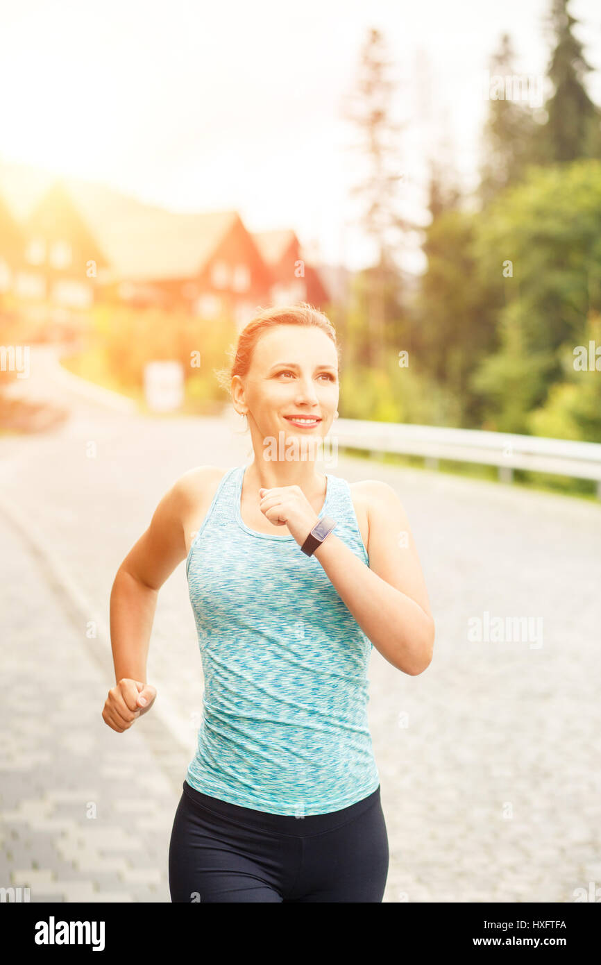 Young athletic girl running on the road in the morning. Attractive ...