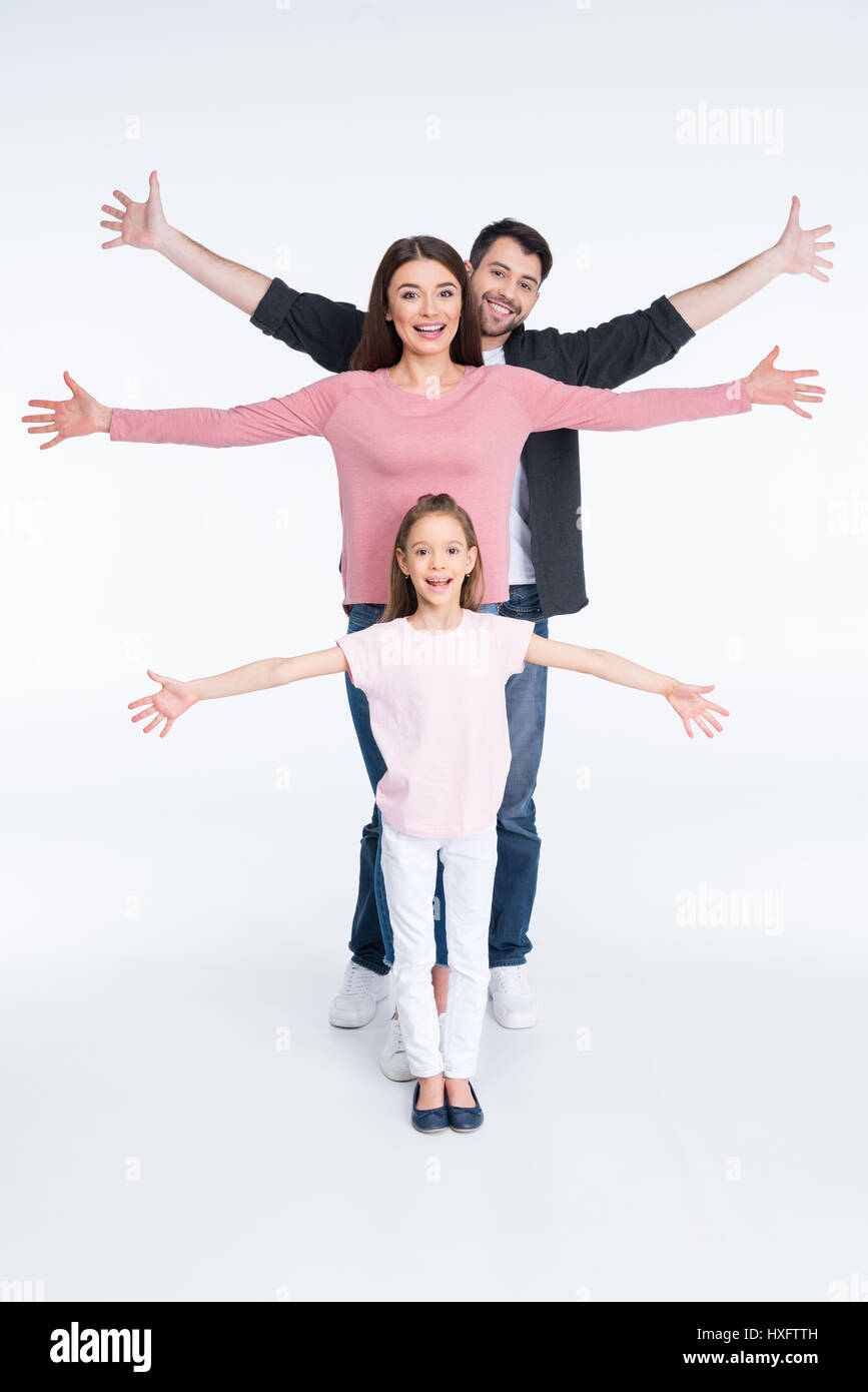 Happy young family with one child standing with open arms on white ...