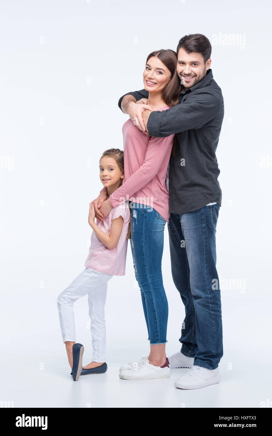 Happy family with one child standing together and hugging on white ...