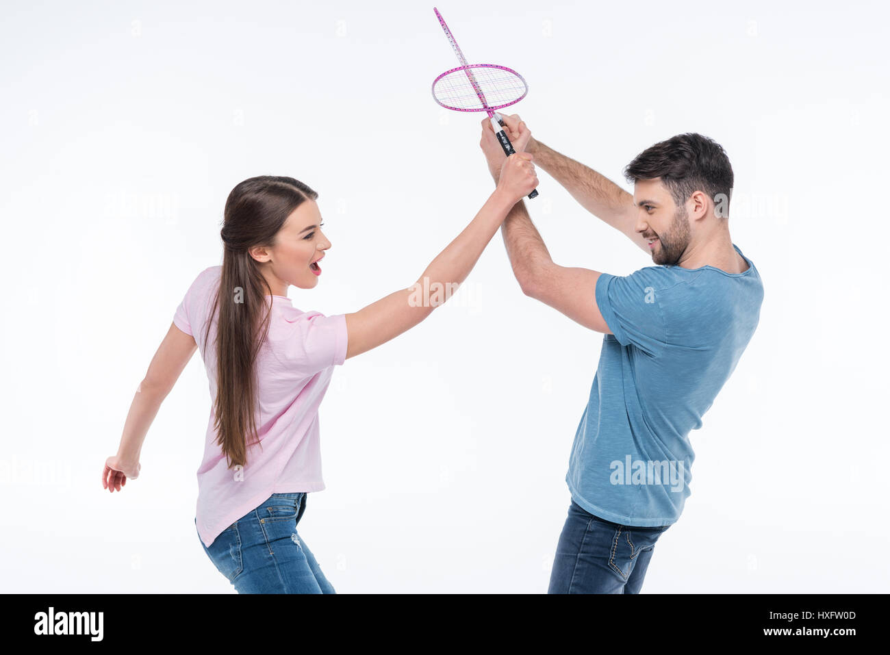 portrait of couple fighting with badminton rackets on white Stock Photo ...