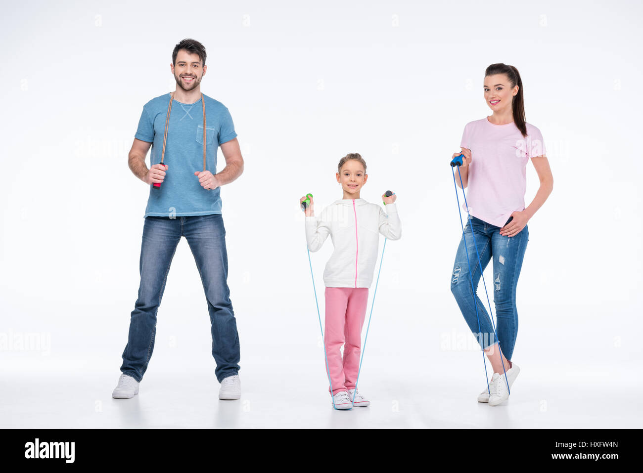 smiling young family with jump ropes on white Stock Photo - Alamy