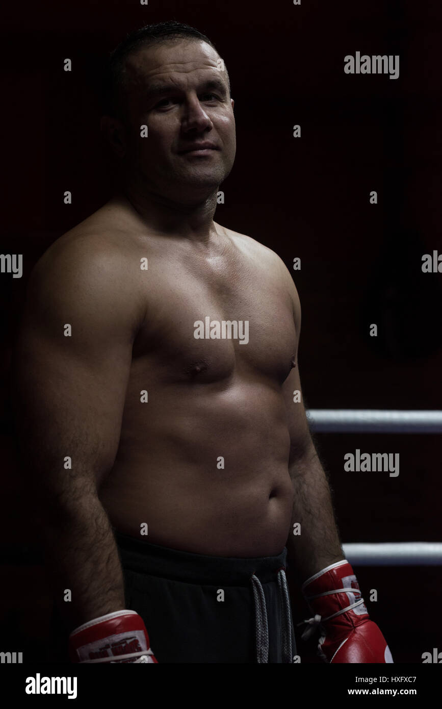 portrait of muscular professional kickboxer who standing in the ring ...