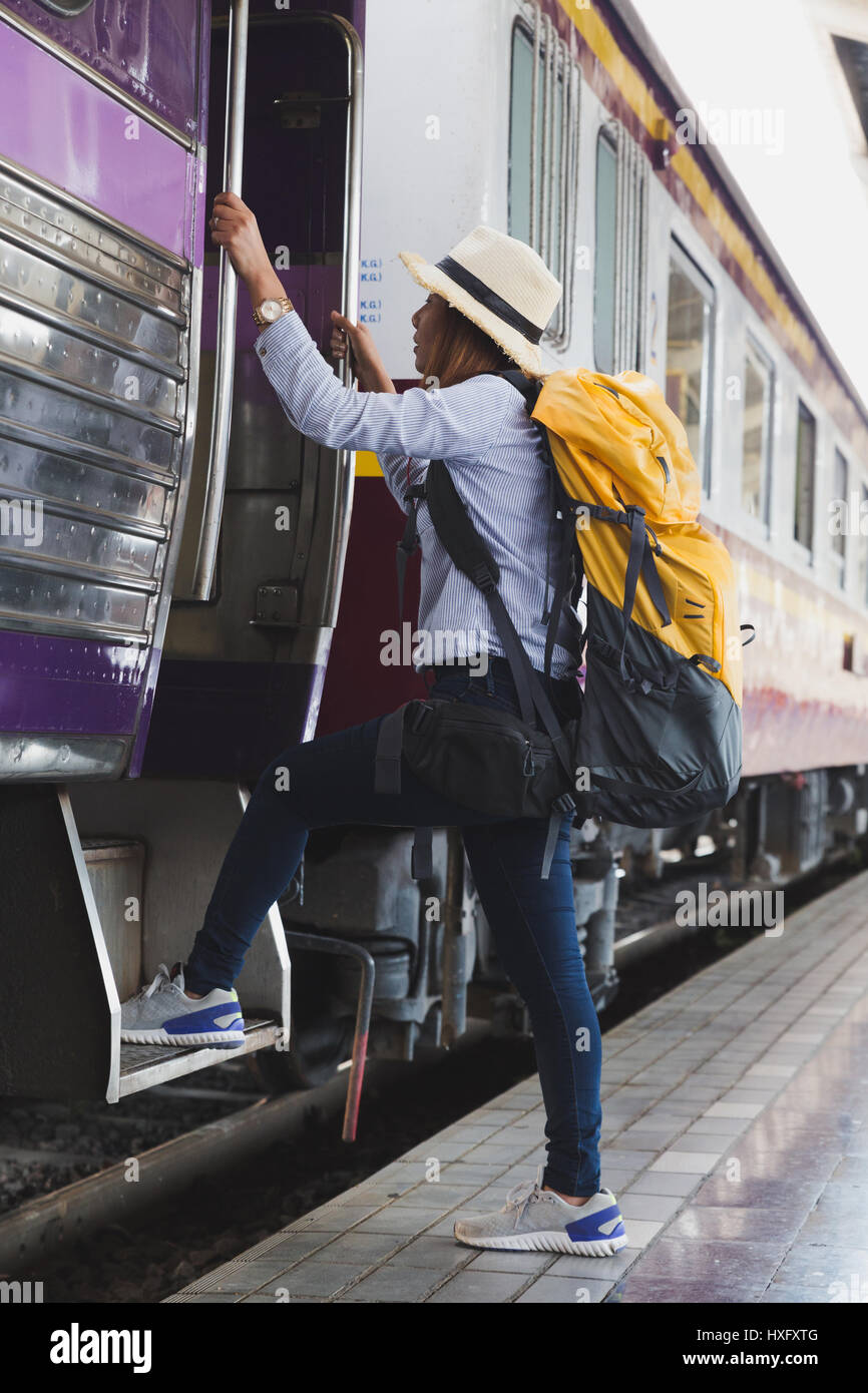 Traveler holding and stepping up to a train with backpack for journey ...