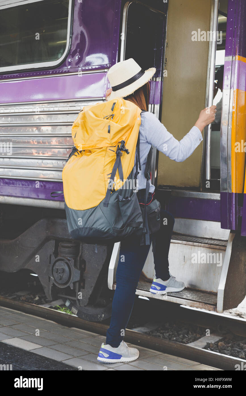 Traveler holding and stepping up to a train with backpack for journey ...