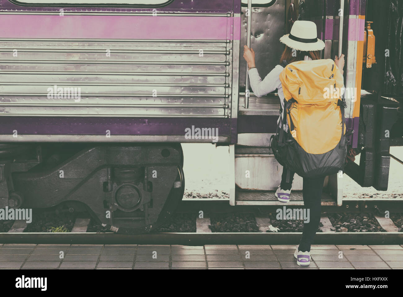 Traveler holding and stepping up to a train with backpack for journey ...