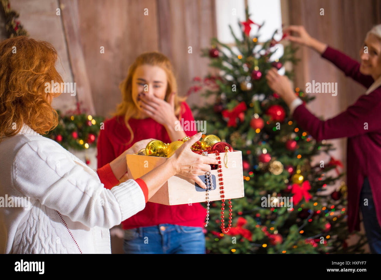Happy family from three generations decorating christmas tree Stock ...