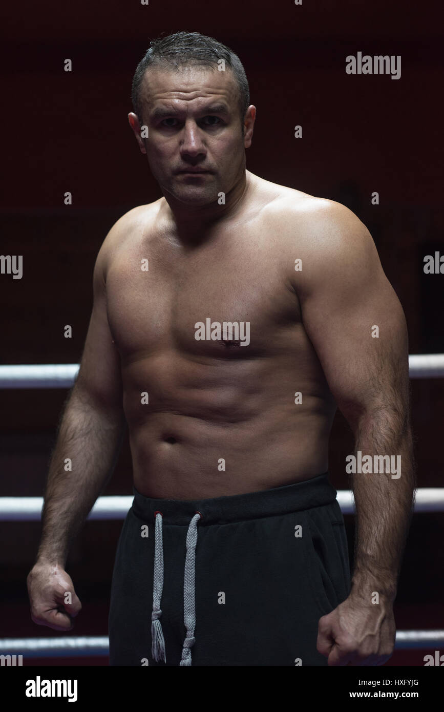 portrait of muscular professional kickboxer who standing in the ring ...