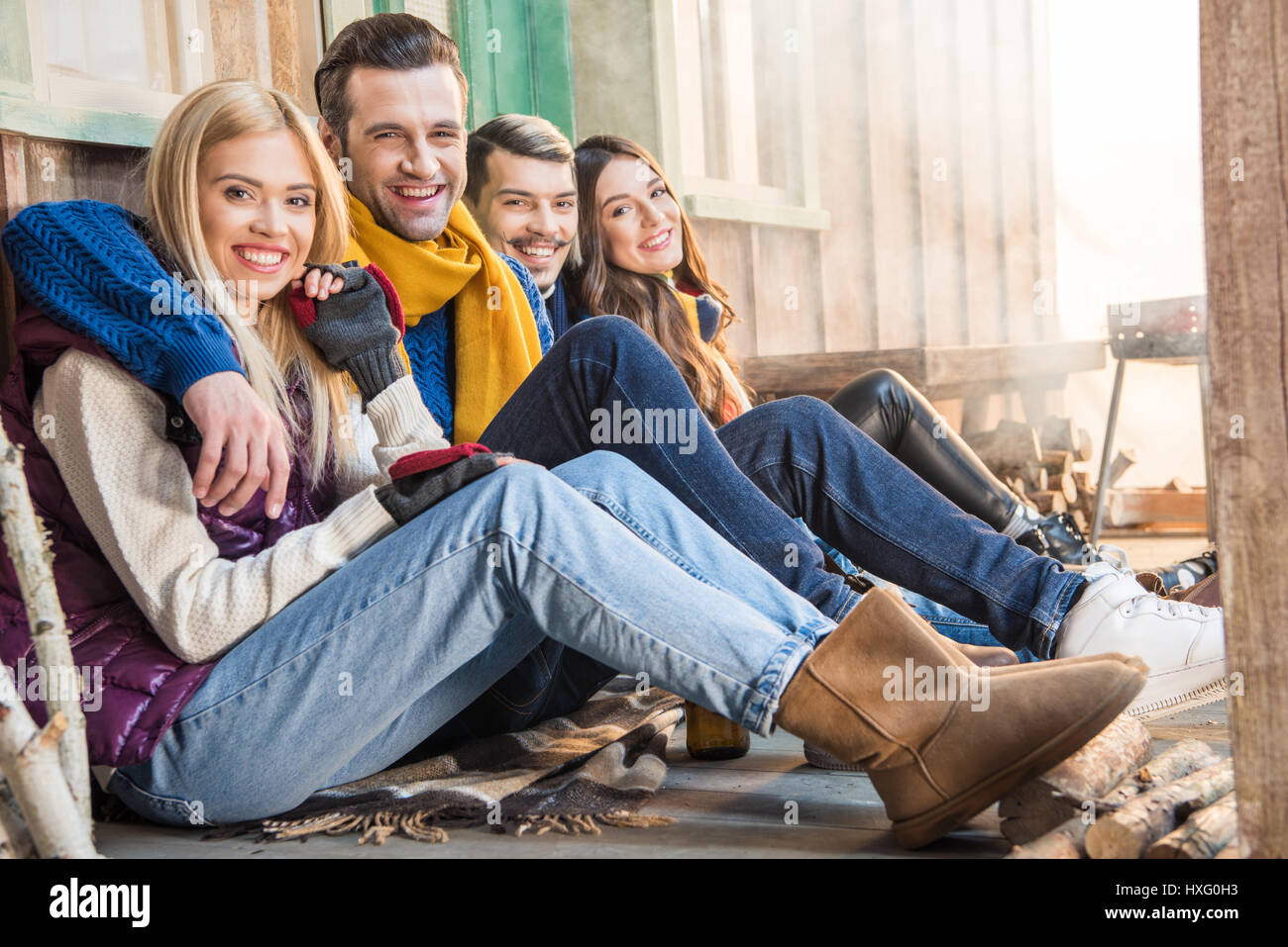 side view of happy friends sitting together and looking to camera Stock ...