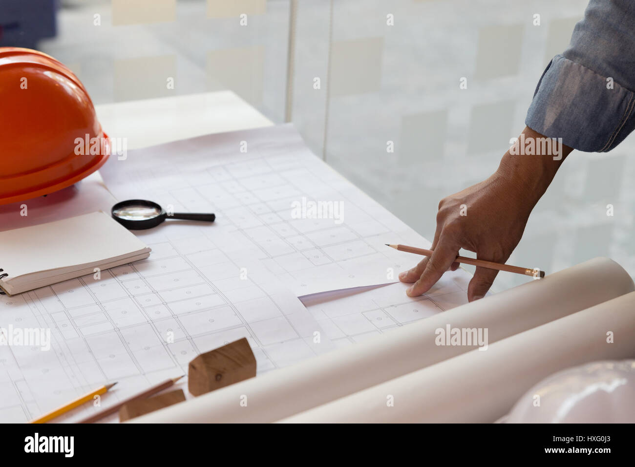 Architect or engineer working on blueprint at workplace - architectural ...