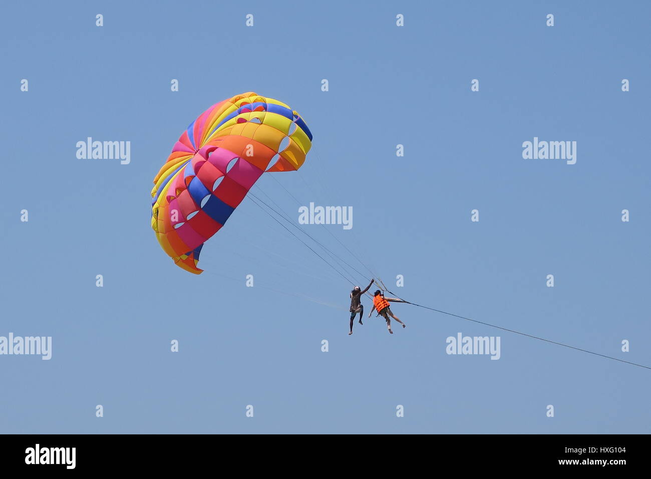 Paragliders enjoy parasailing with colourful parachute. Indigenous ...