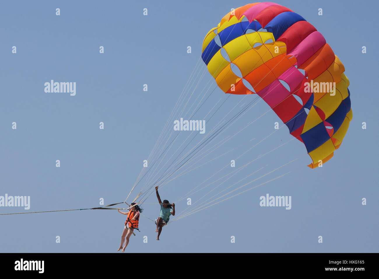 Paragliders enjoy parasailing with colourful parachute. Indigenous ...