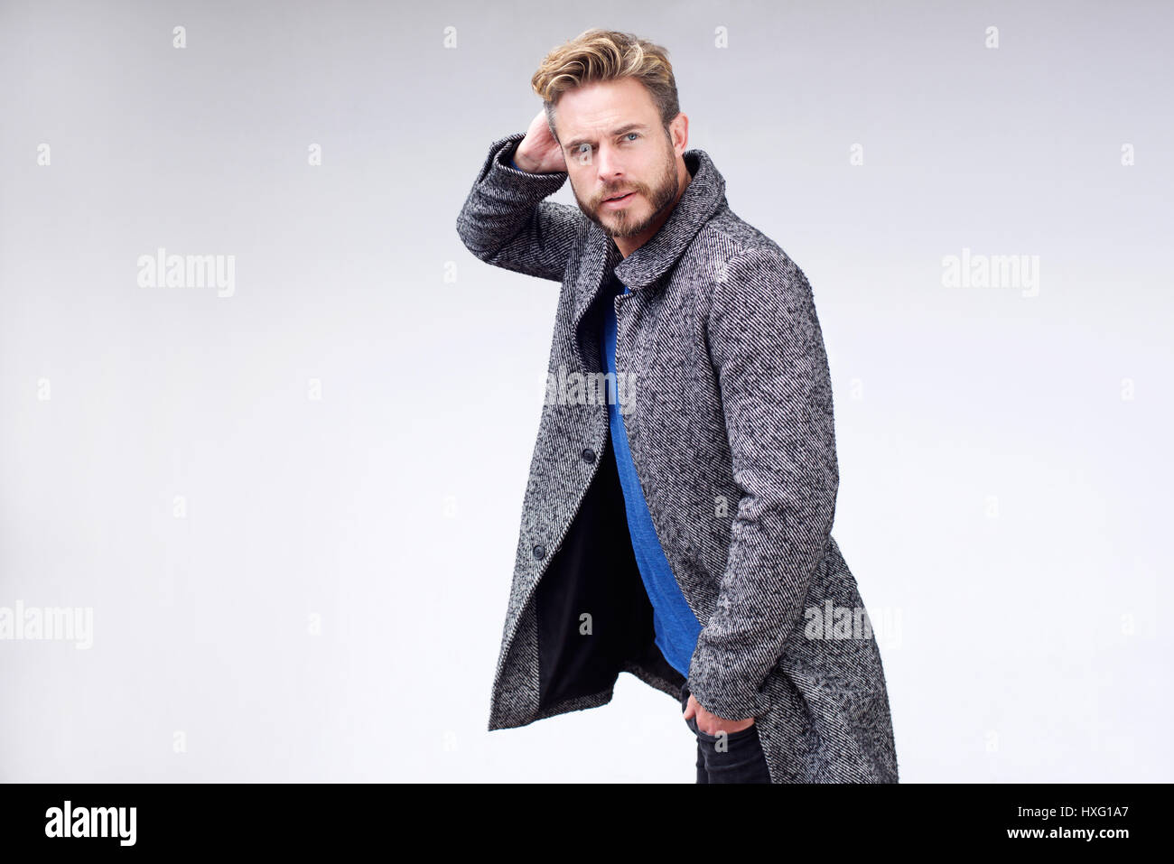 Portrait male fashion model walking with hand in hair Stock Photo - Alamy