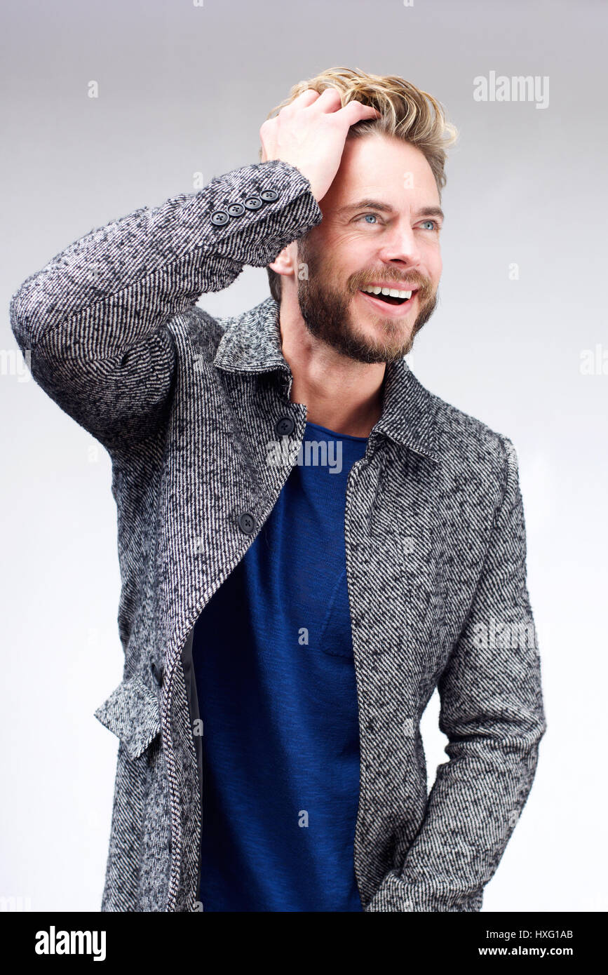 Portrait of a handsome male fashion model smiling with hand in hair ...
