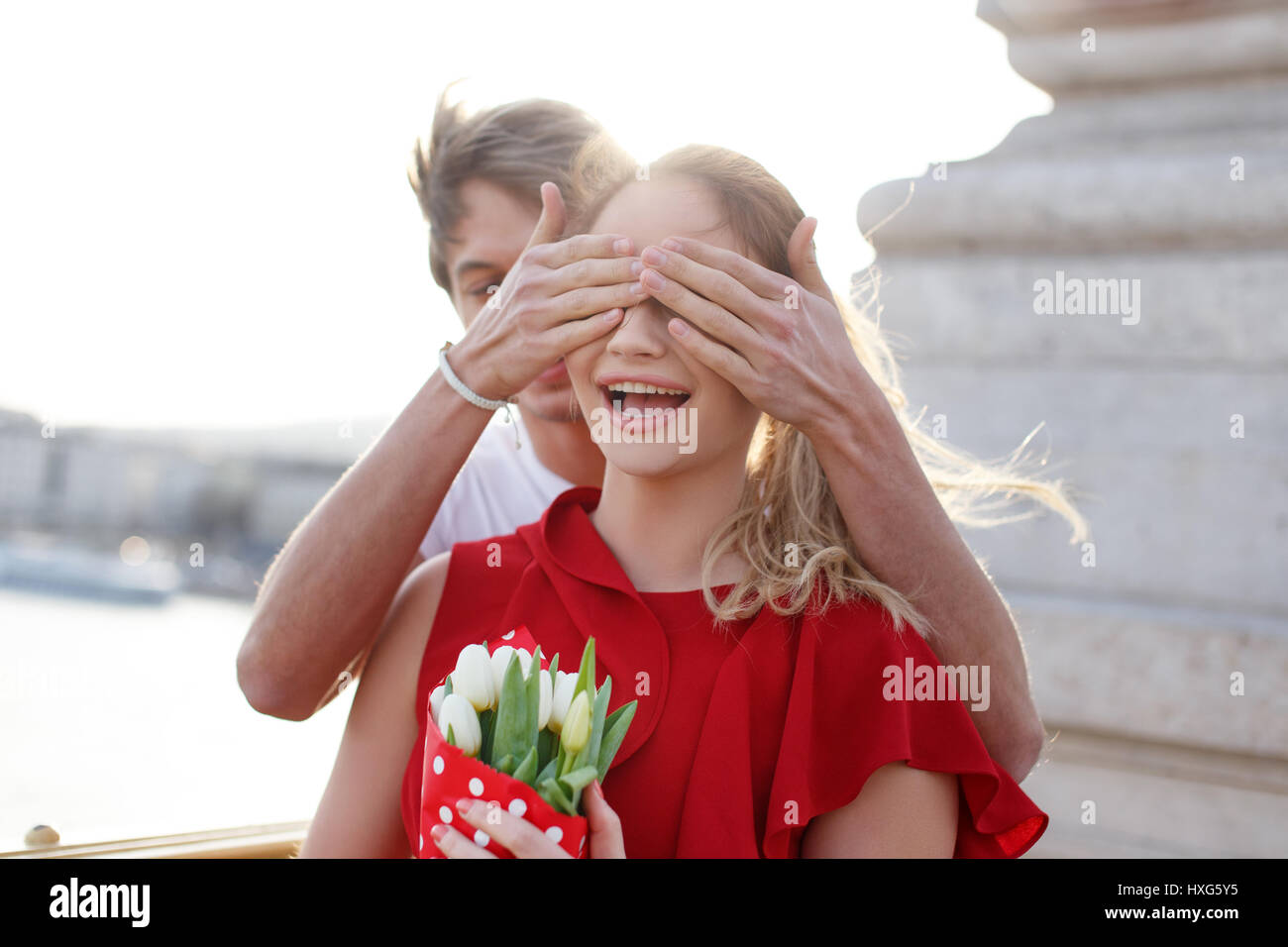 Surprised woman in red dress get bouquet from man on first date Stock ...
