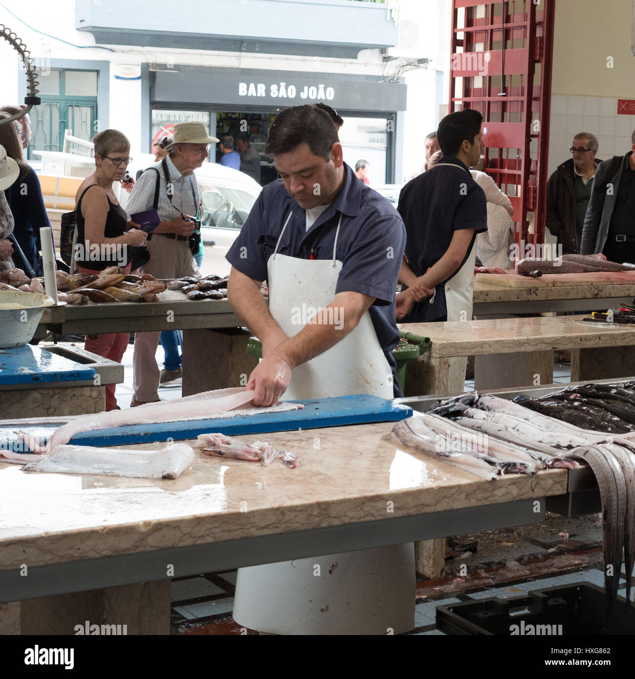 A fishmonger prepares a black scabbard fish into fillets for sale athe ...