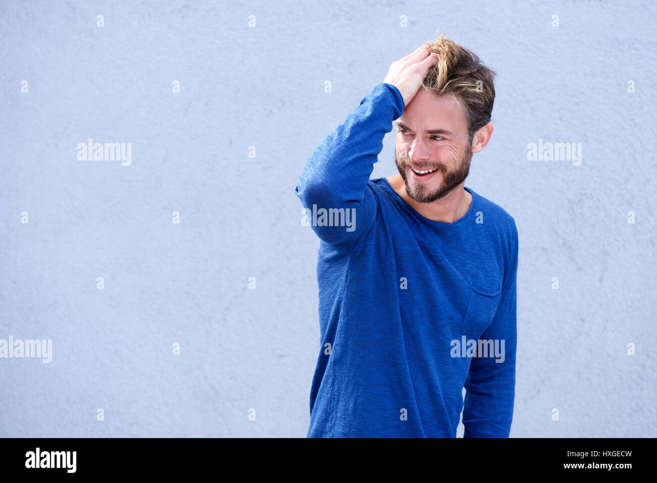 Portrait of a male fashion model smiling with hand in hair Stock Photo ...