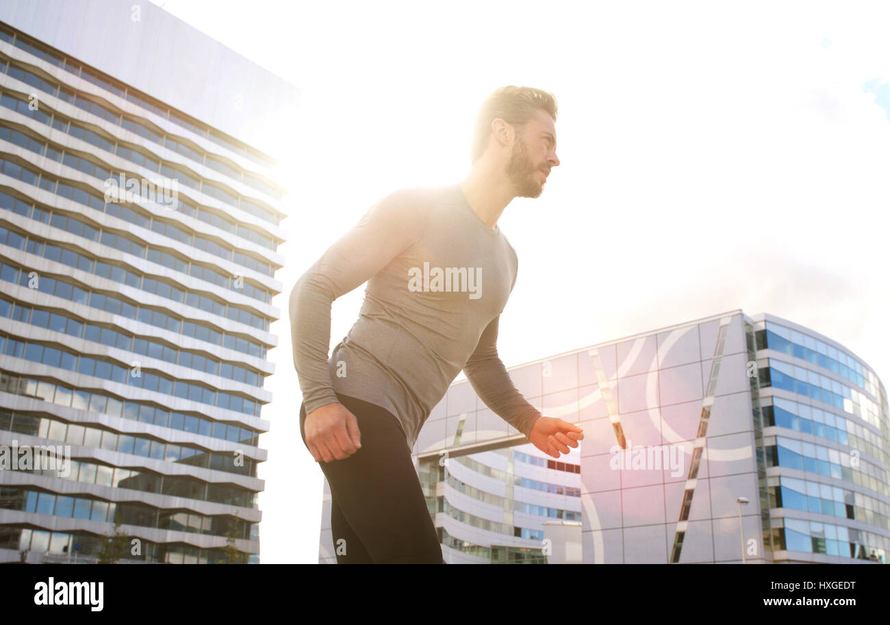 Side portrait of a active man running outside in the city Stock Photo ...