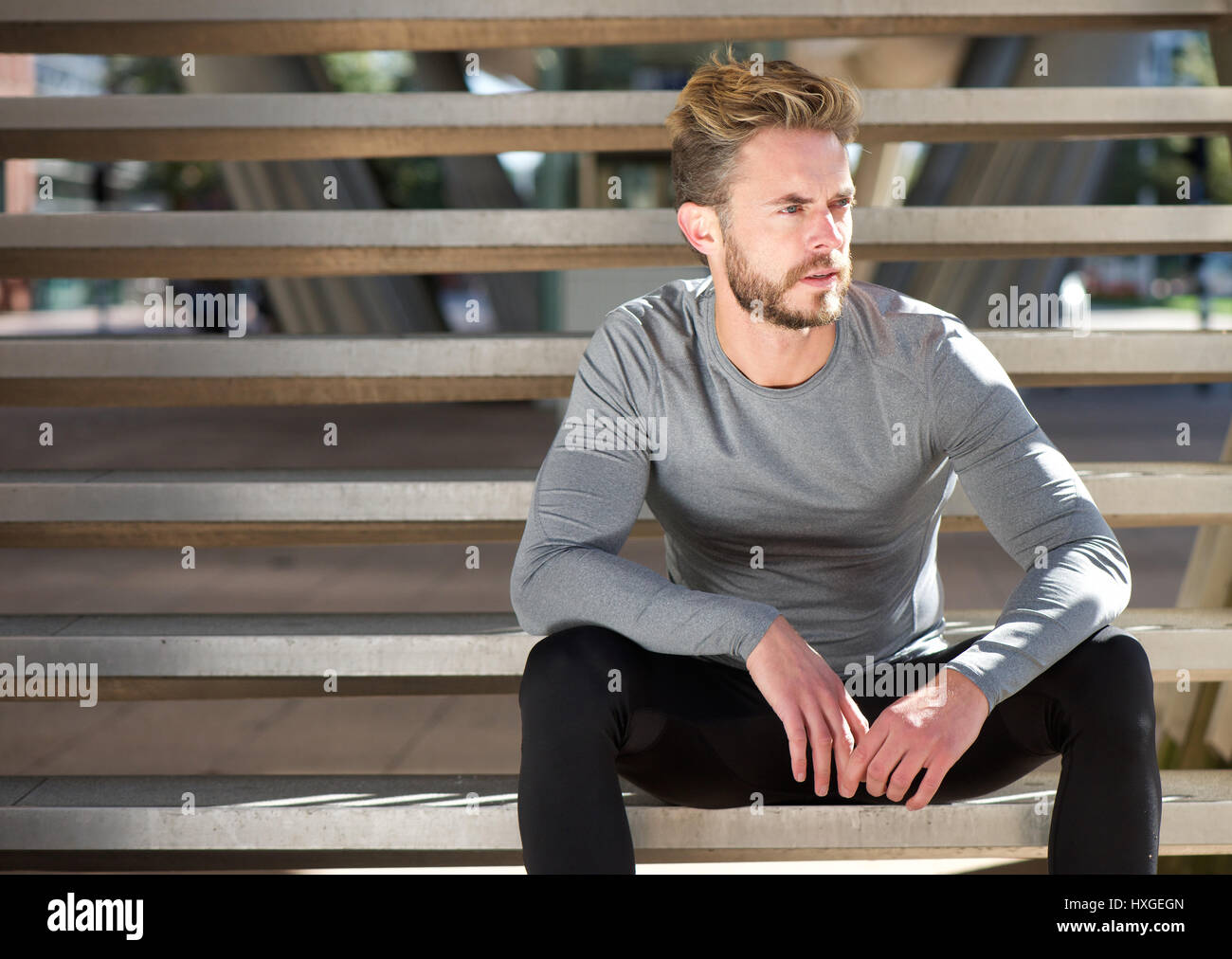Portrait of a cool fit man sitting on steps outdoors Stock Photo - Alamy