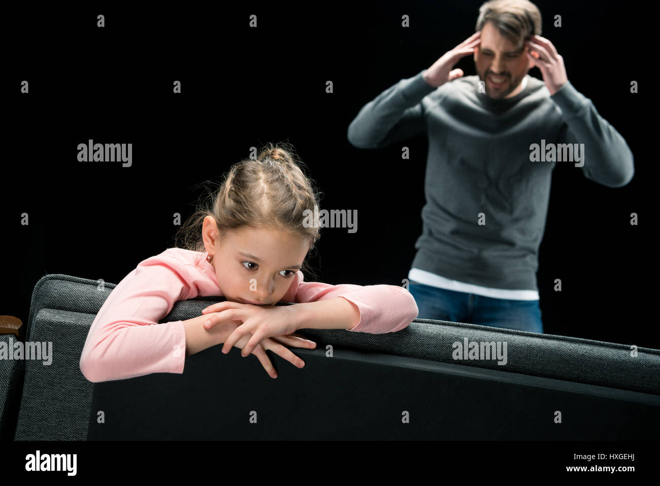 Aggressive father standing near upset daughter sitting on couch, family ...