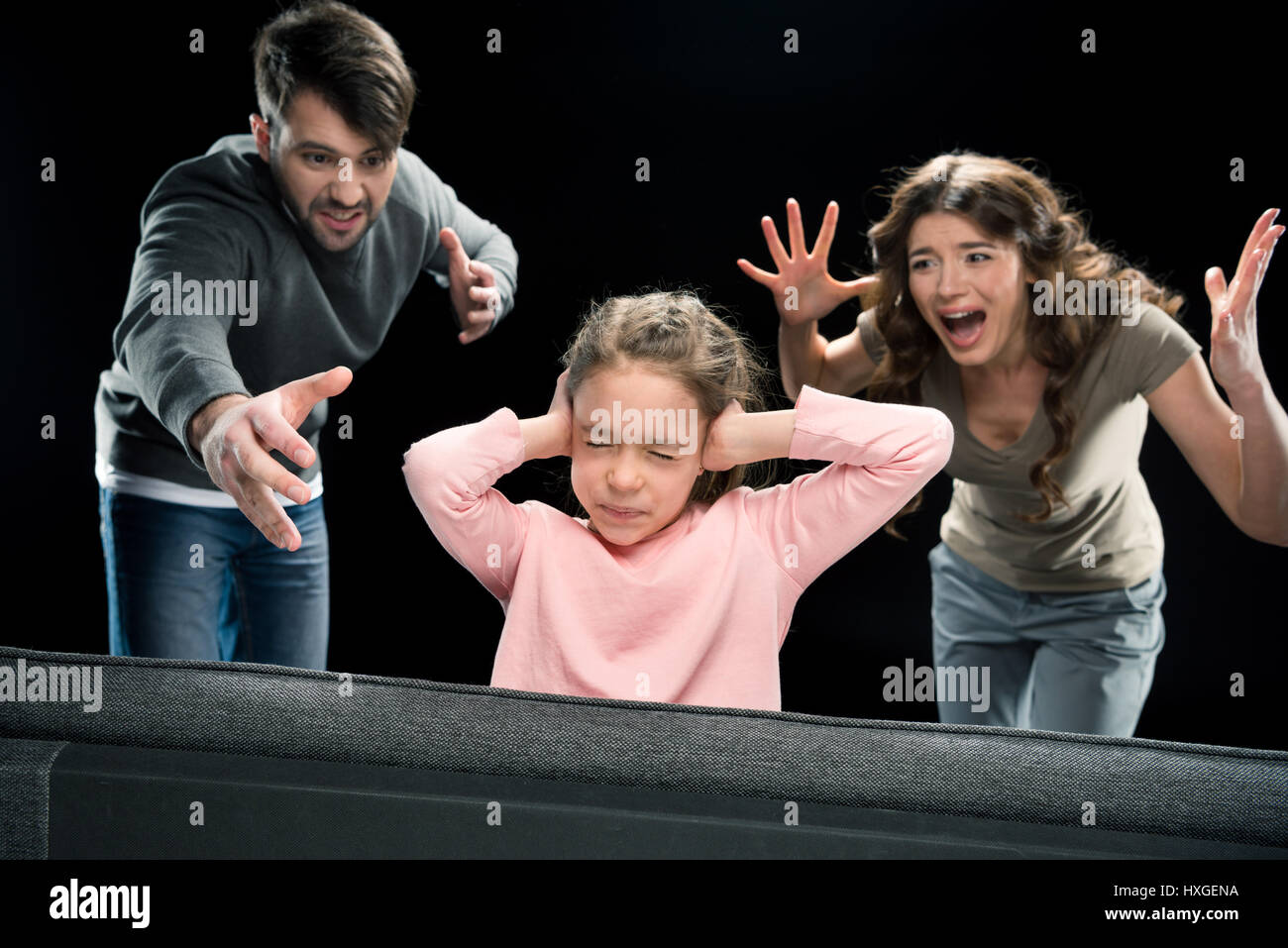 Emotional parents screaming at little daughter closing ears with hands ...