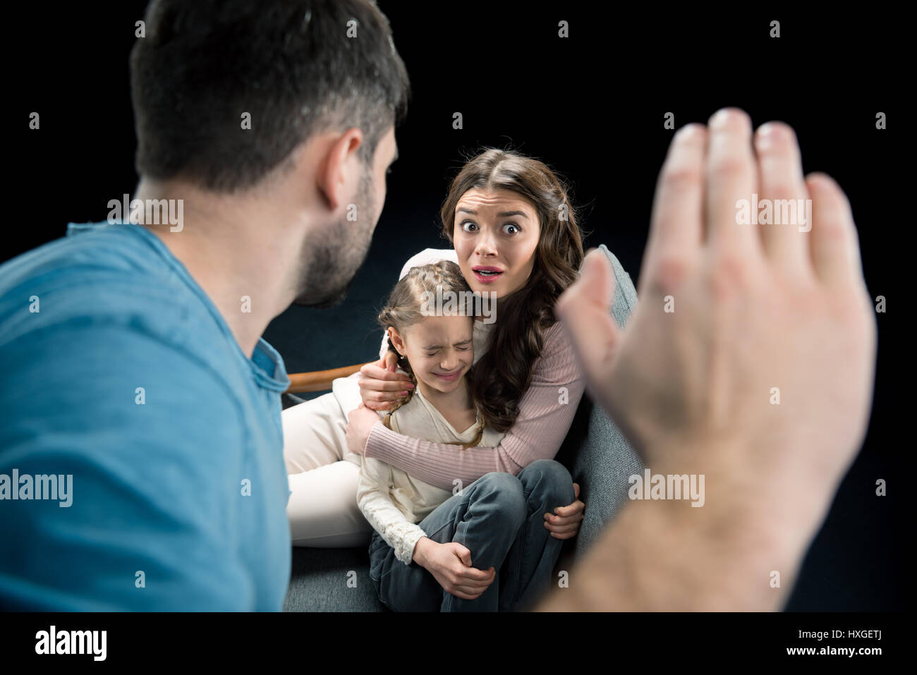 mother covering crying daughter from aggressive father, family violence ...