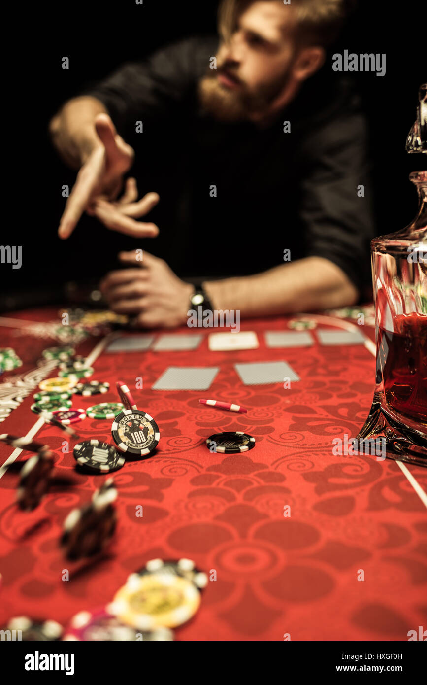 Bearded man throwing poker chips on table while playing poker Stock ...