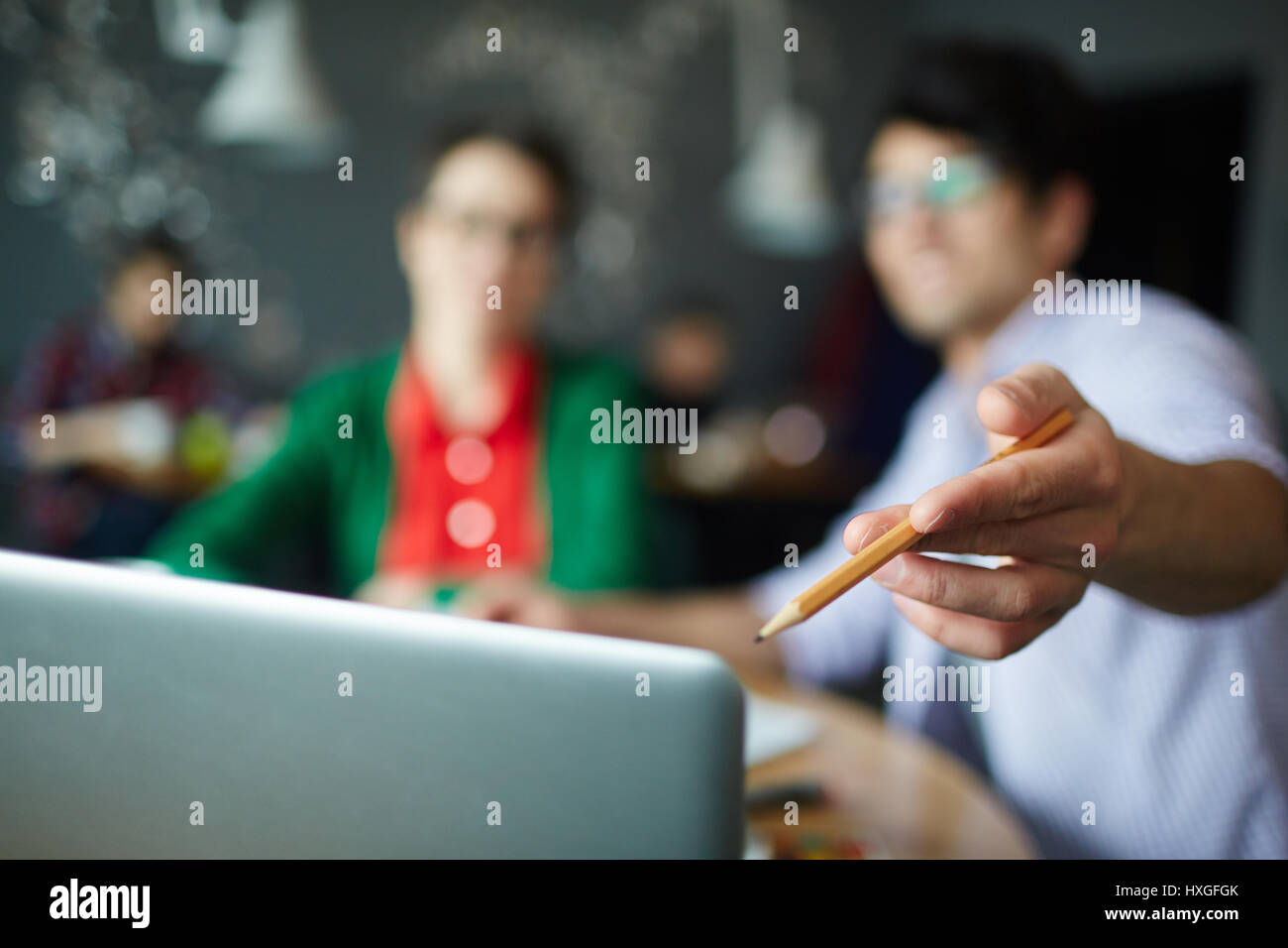 Human hand with pencil pointing at laptop monitor during explanations ...