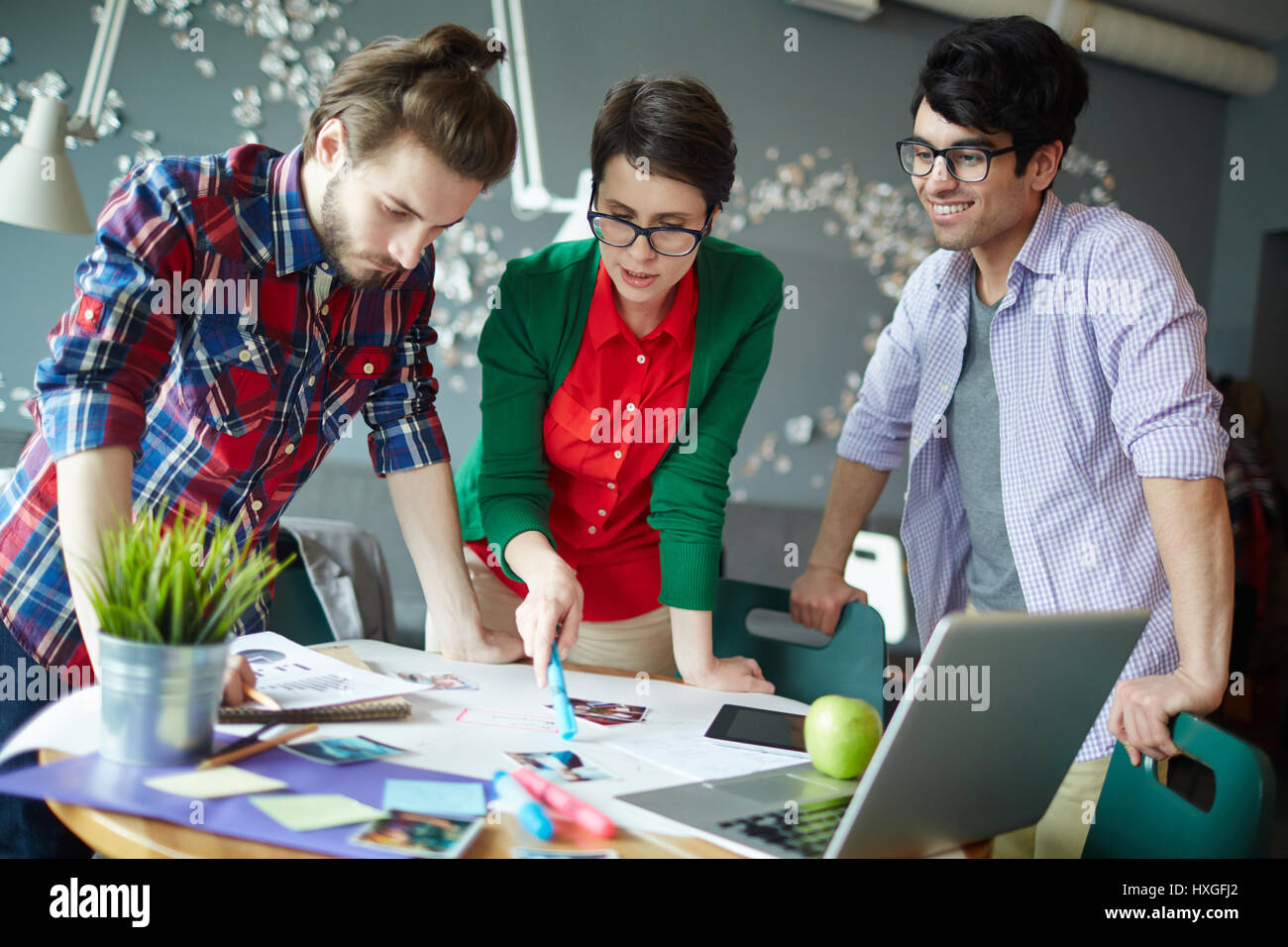 Businesswoman pointing at image on table during explanation Stock Photo ...