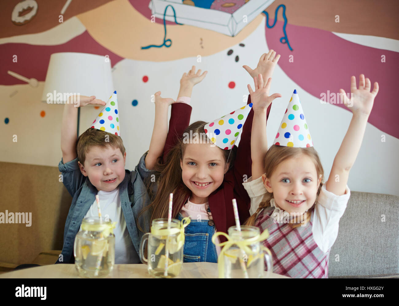 Ecstatic friends raising hands while enjoying party Stock Photo - Alamy