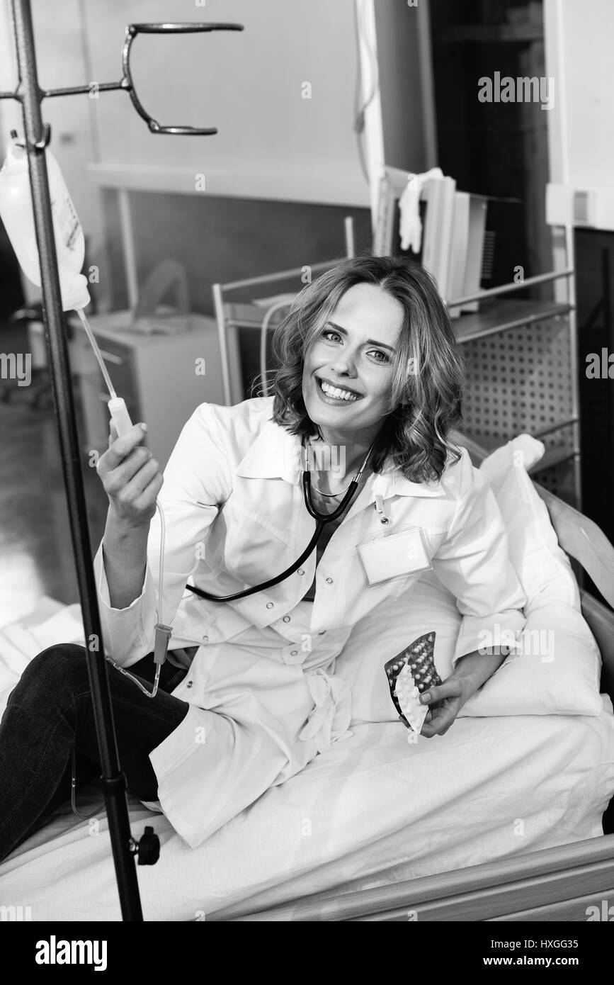 black and white portrait of smiling doctor with medicines in hospital ...