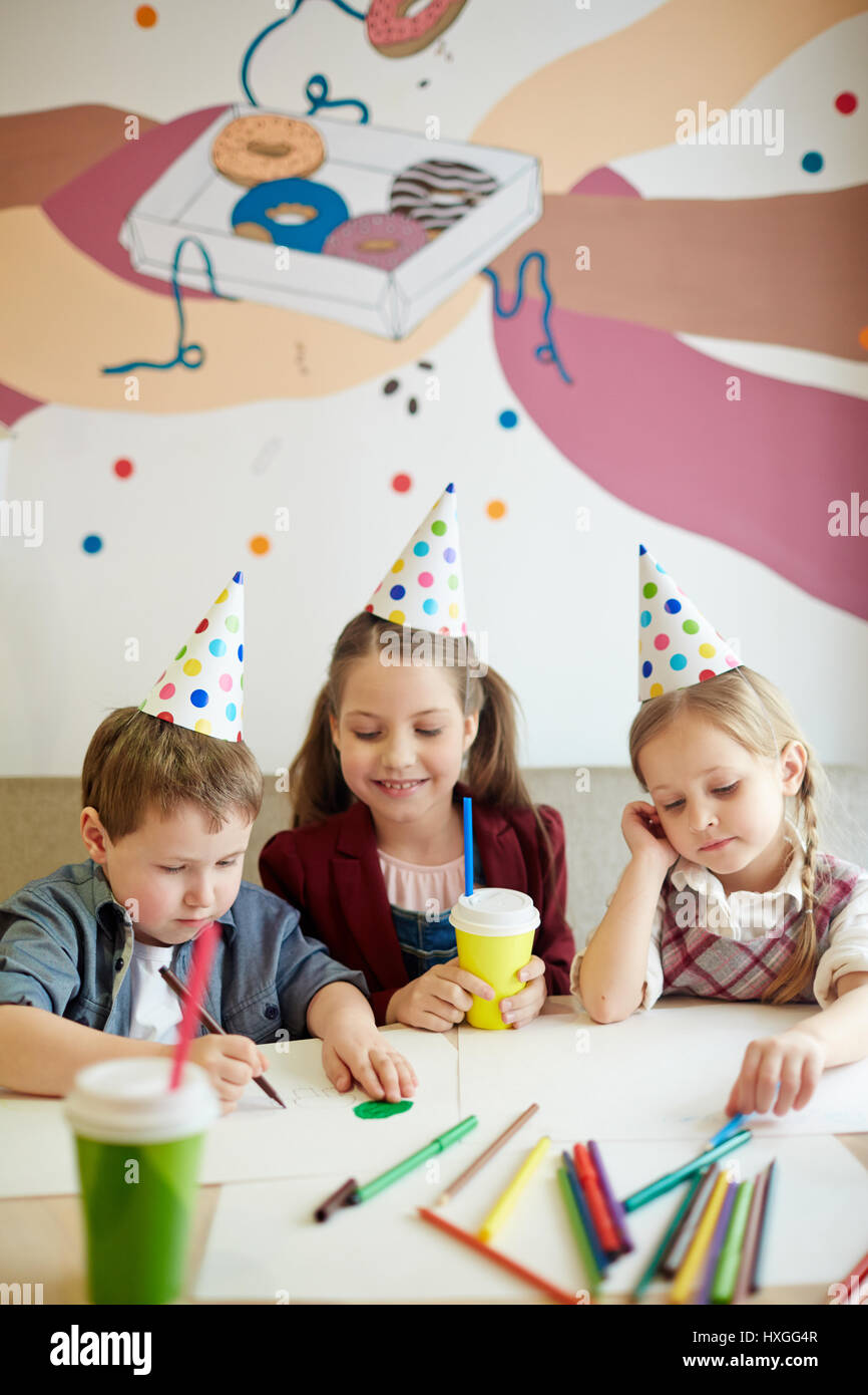 Creative children drawing with crayons while having drinks Stock Photo ...
