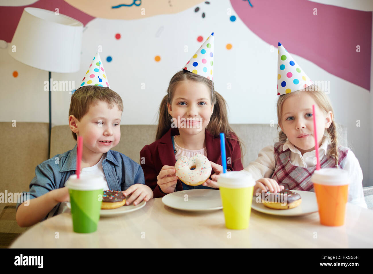 Happy children eating donuts at birthday party Stock Photo - Alamy