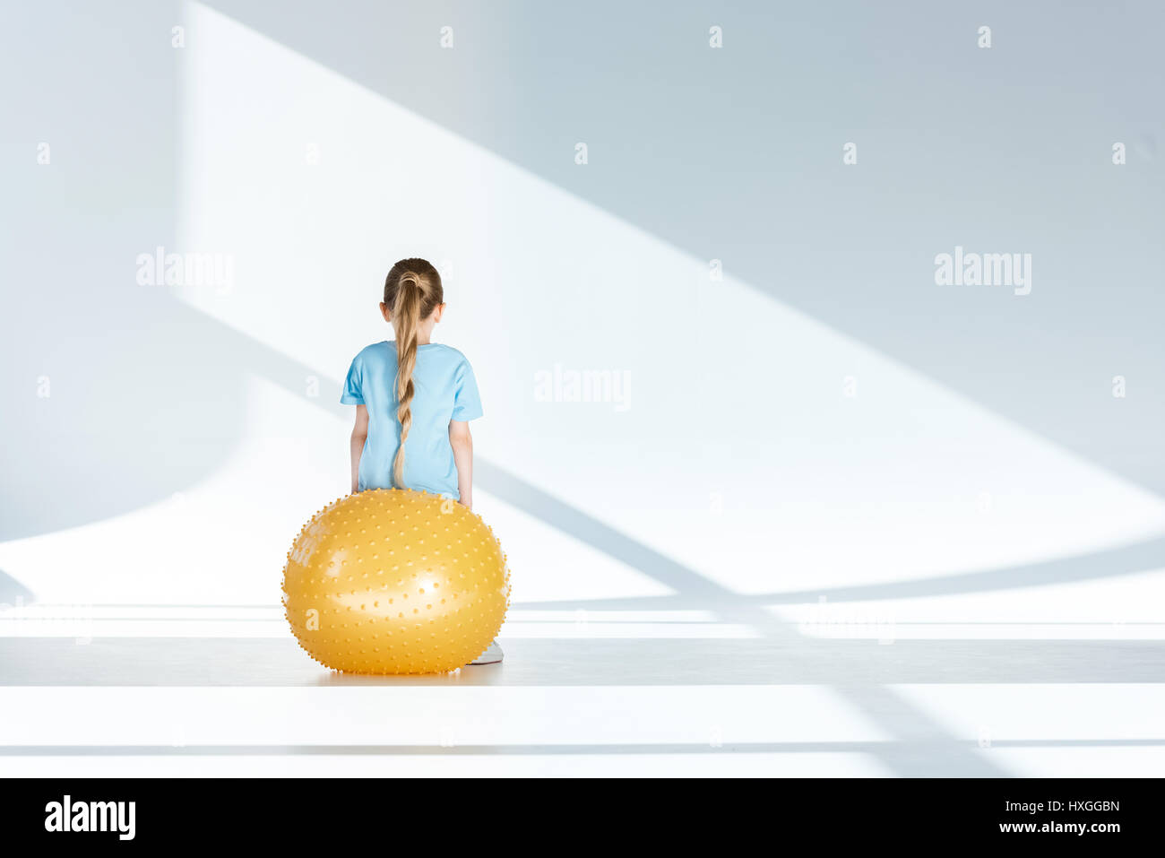 Back view of little girl sitting and exercising on fitness ball Stock ...